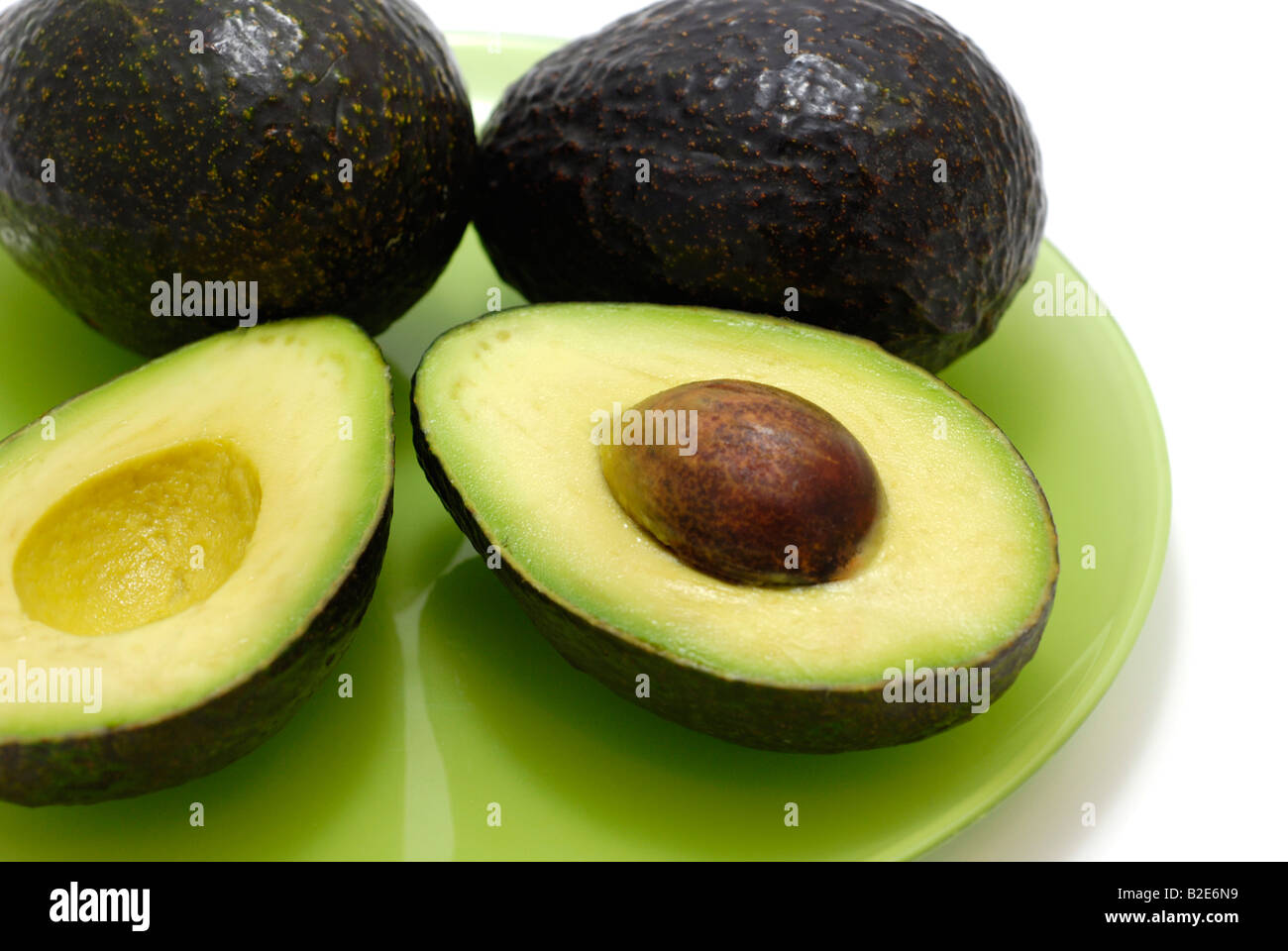 Two Avocados One Sliced in Half, Seed exposed Stock Photo - Alamy