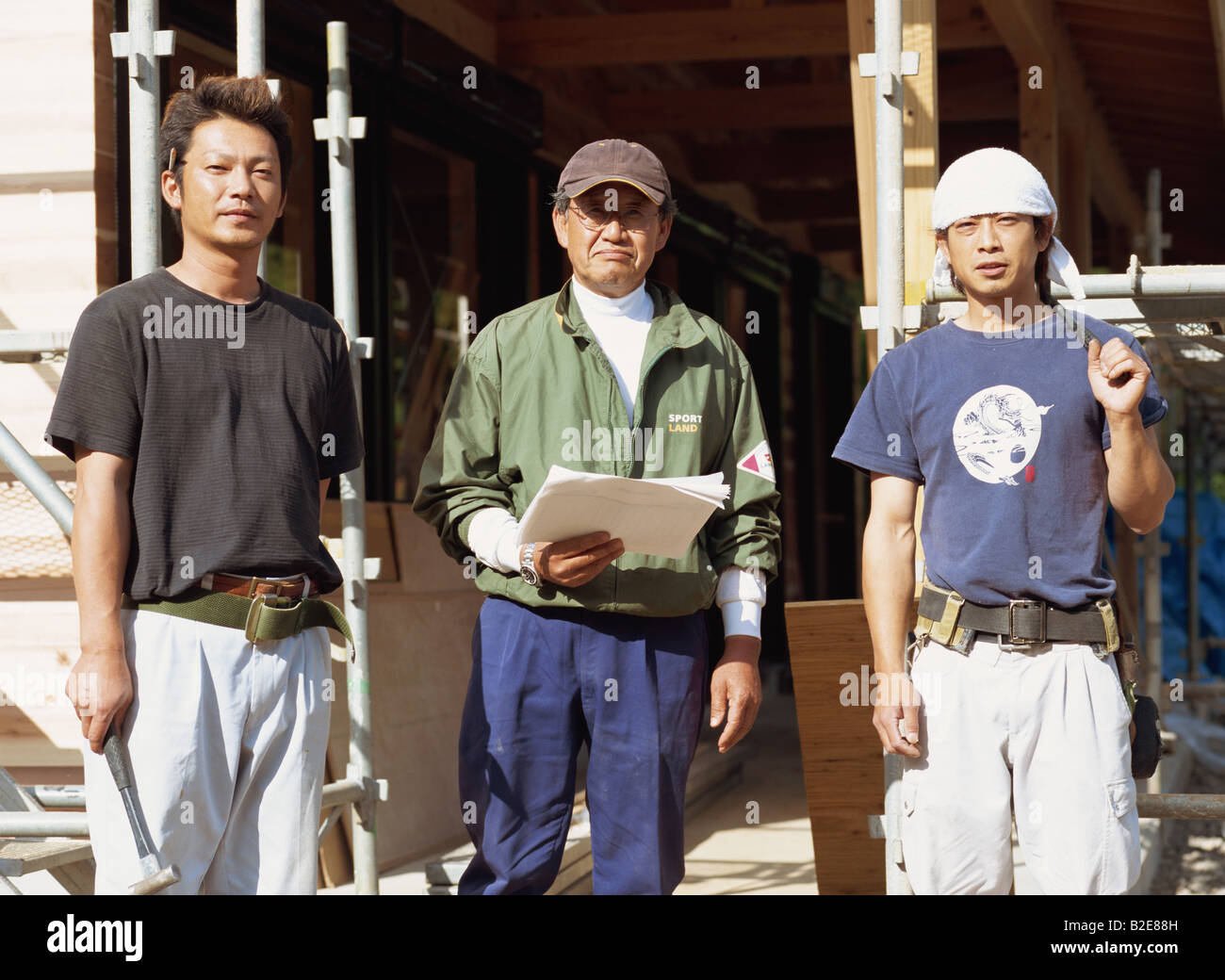 Three young carpenters building a house Stock Photo - Alamy