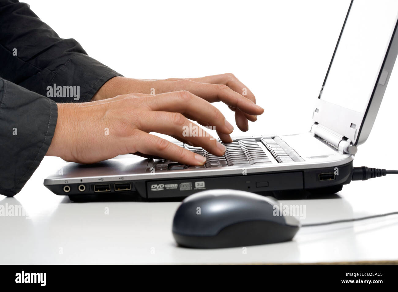 Close-up of computer mouse and person's hands using laptop Stock Photo ...