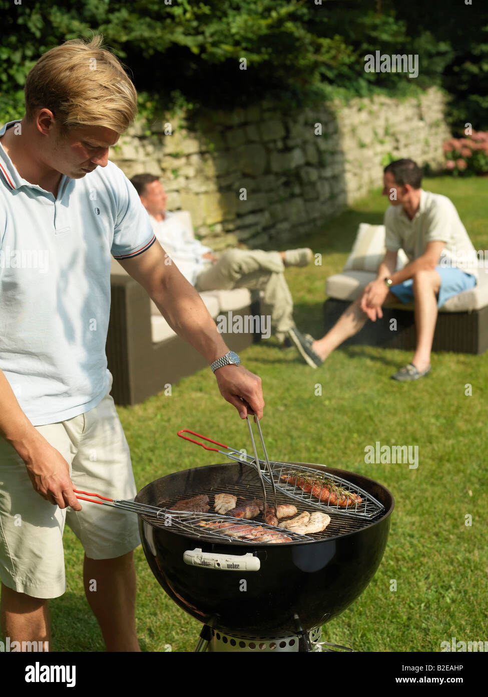 Group of men having barbecue Stock Photo - Alamy