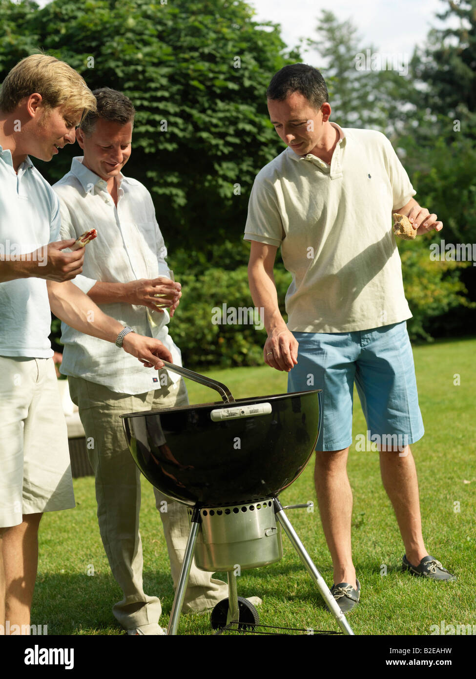 Group of men having barbecue Stock Photo - Alamy