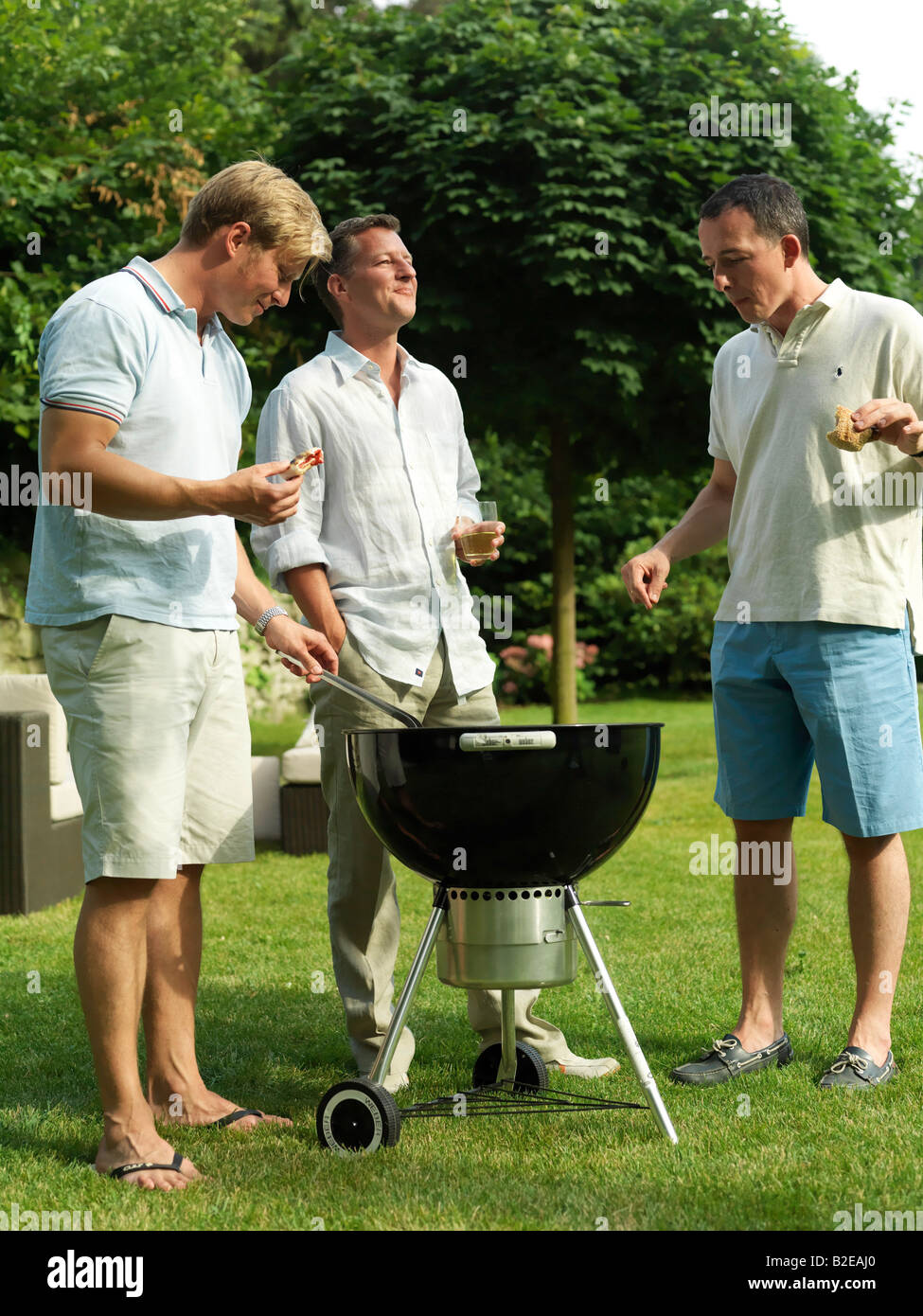 Group of men having barbecue Stock Photo - Alamy