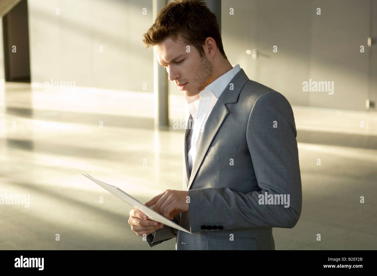 Businessman reading a magazine Stock Photo - Alamy