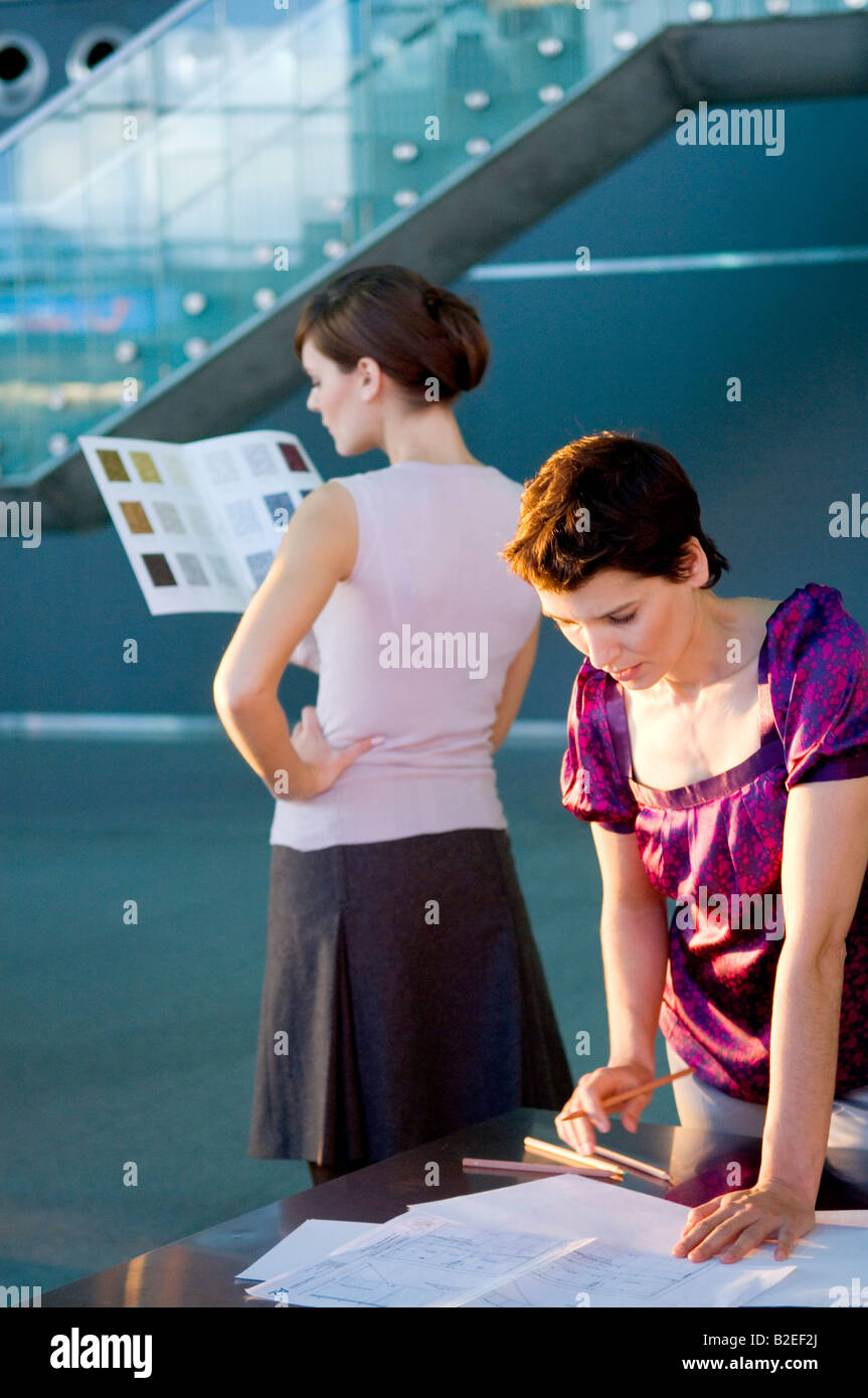 Mid adult woman making a blueprint with a young woman looking at a ...