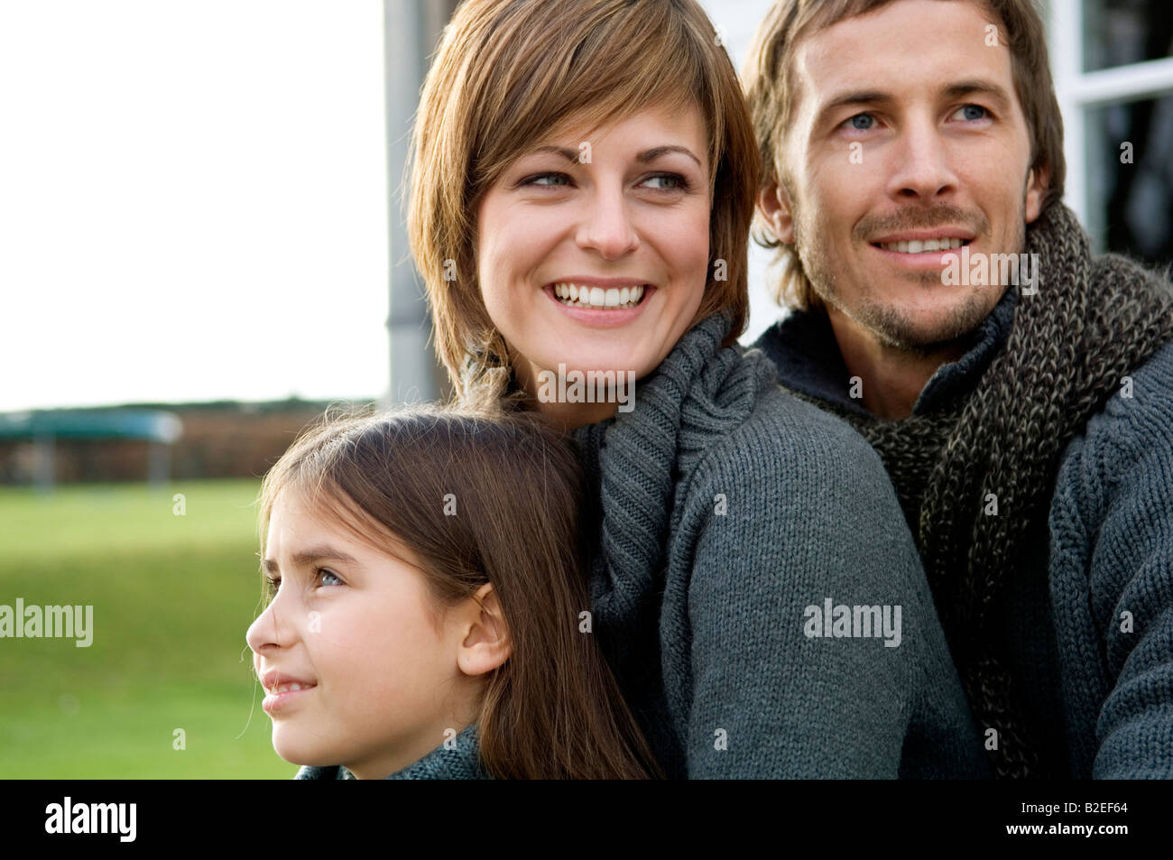Close-up of a girl looking away with her parents smiling Stock Photo ...