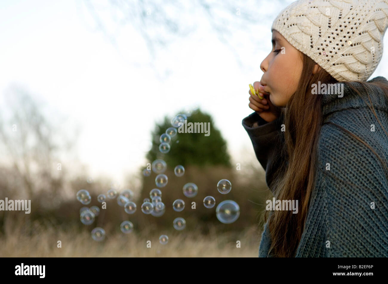 Side profile of a girl blowing bubbles with a bubble wand Stock Photo ...