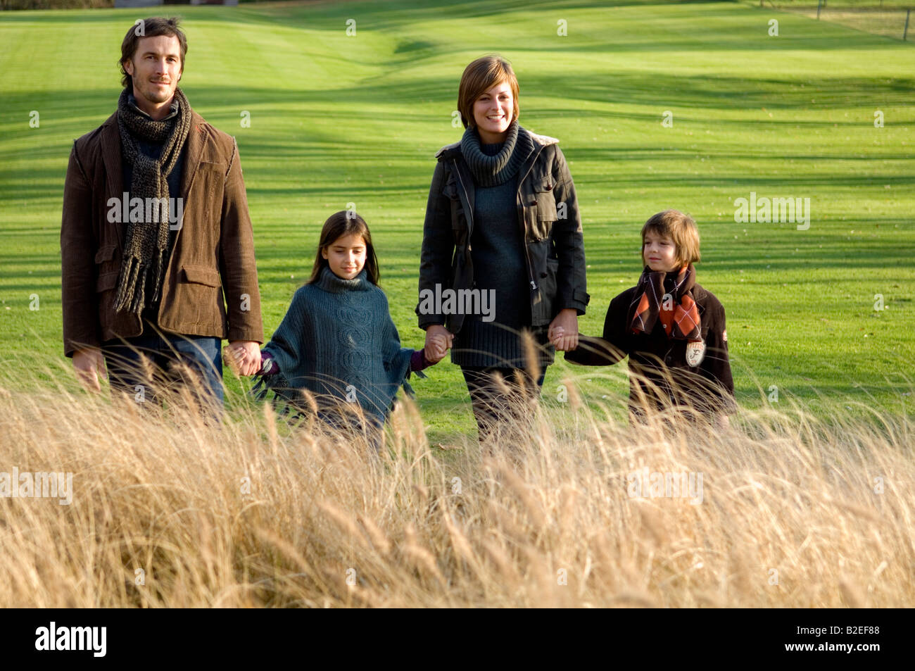 Two children with their parents walking in a park Stock Photo - Alamy