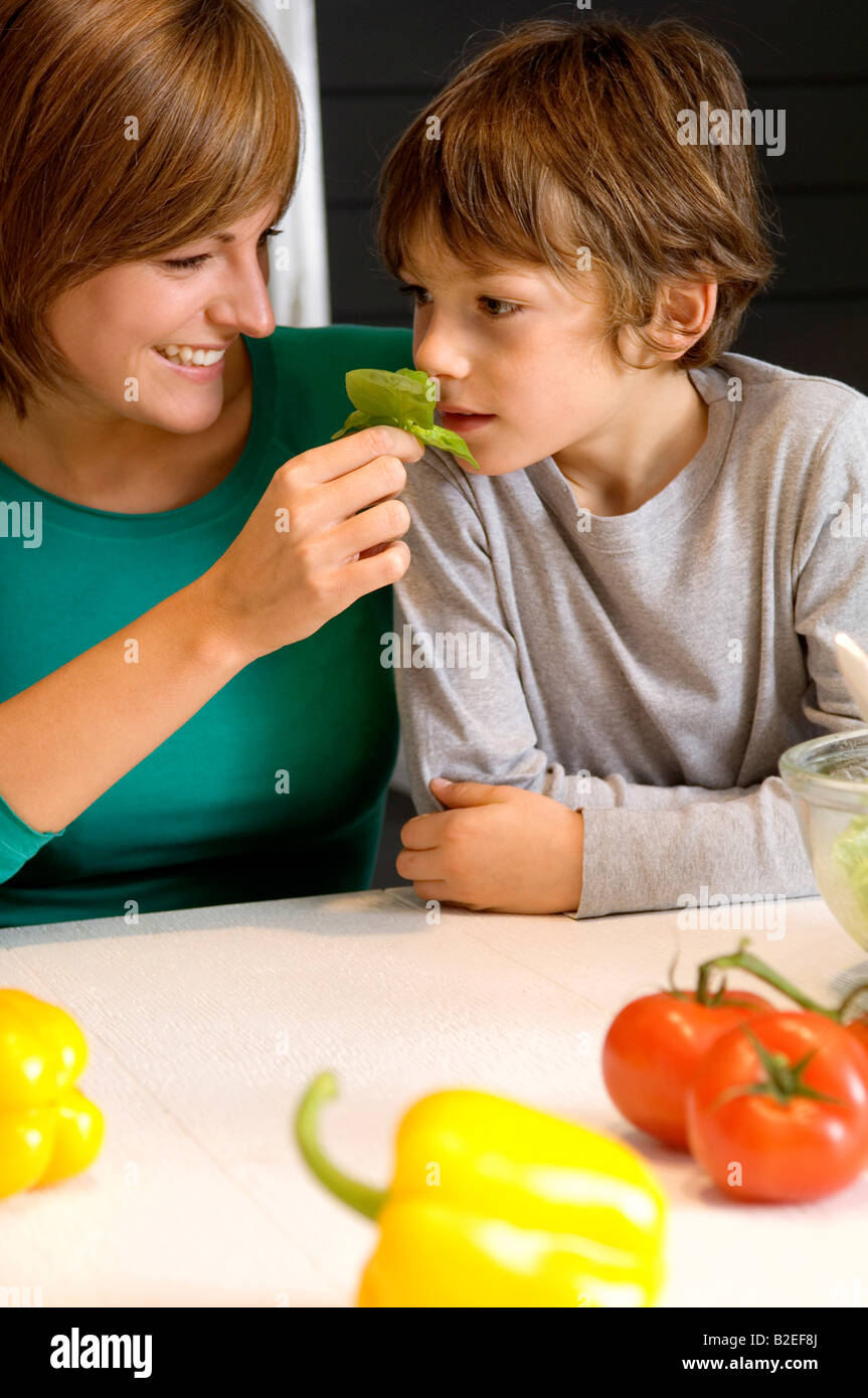 Young woman feeding basil to her son Stock Photo - Alamy