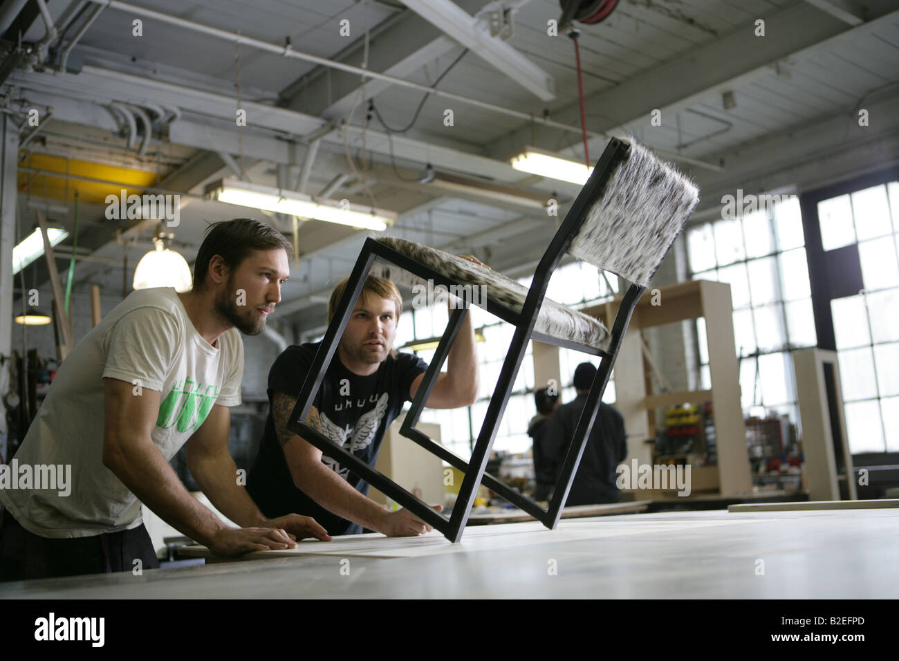 Men inspecting chair in warehouse Stock Photo - Alamy