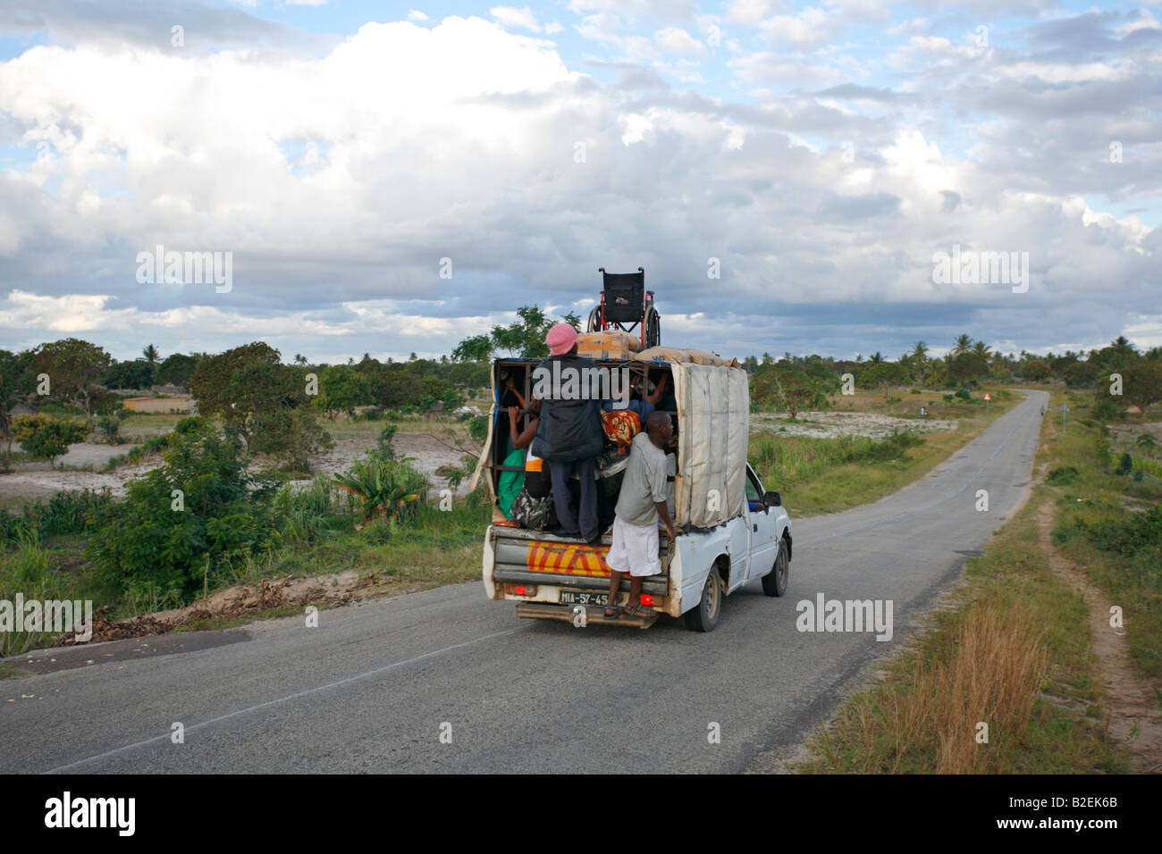 Overloaded bakkie on a rural road in Inhambane with passengers standing ...