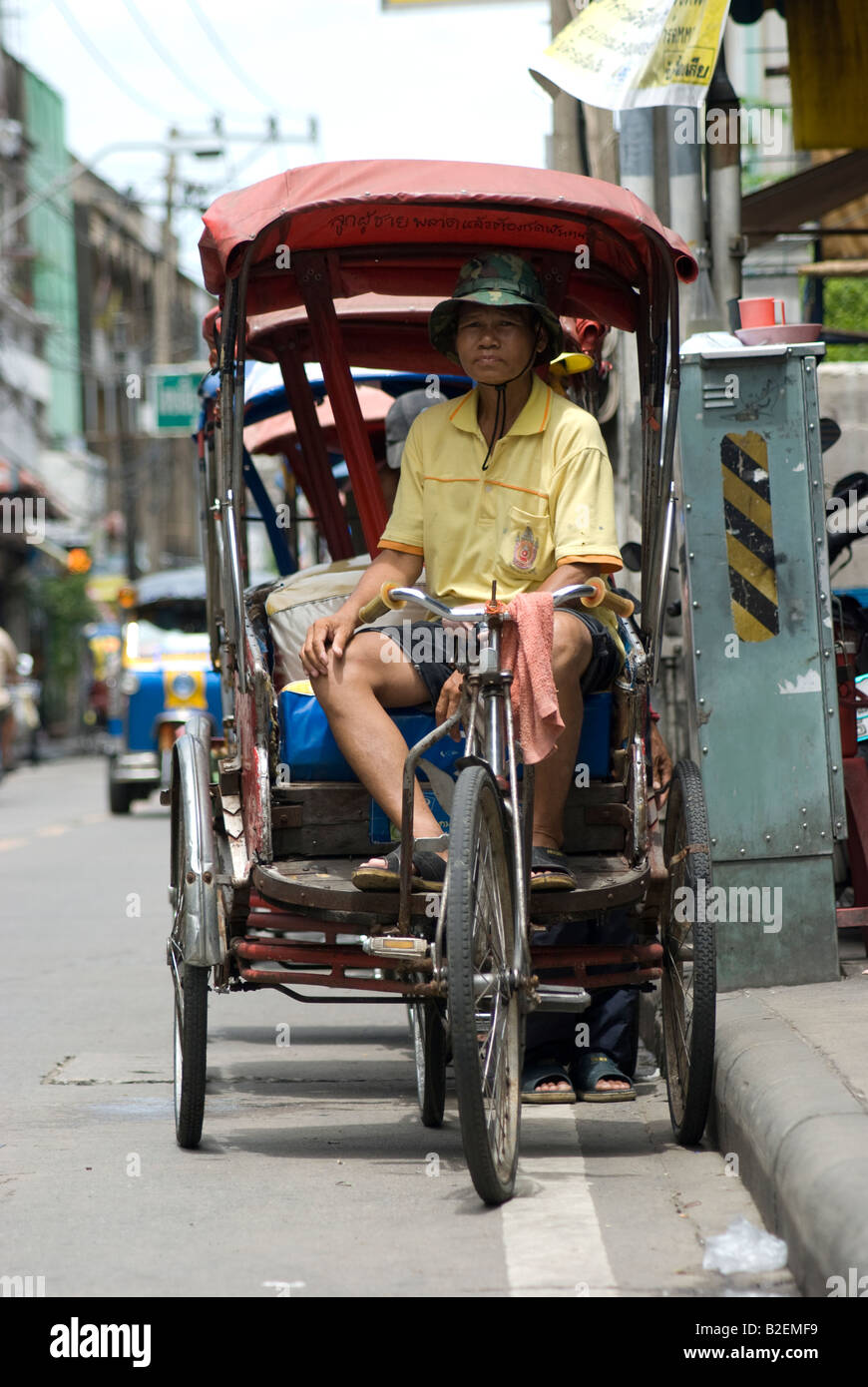 Traditional trishaw with its driver waiting for passengers Stock Photo ...