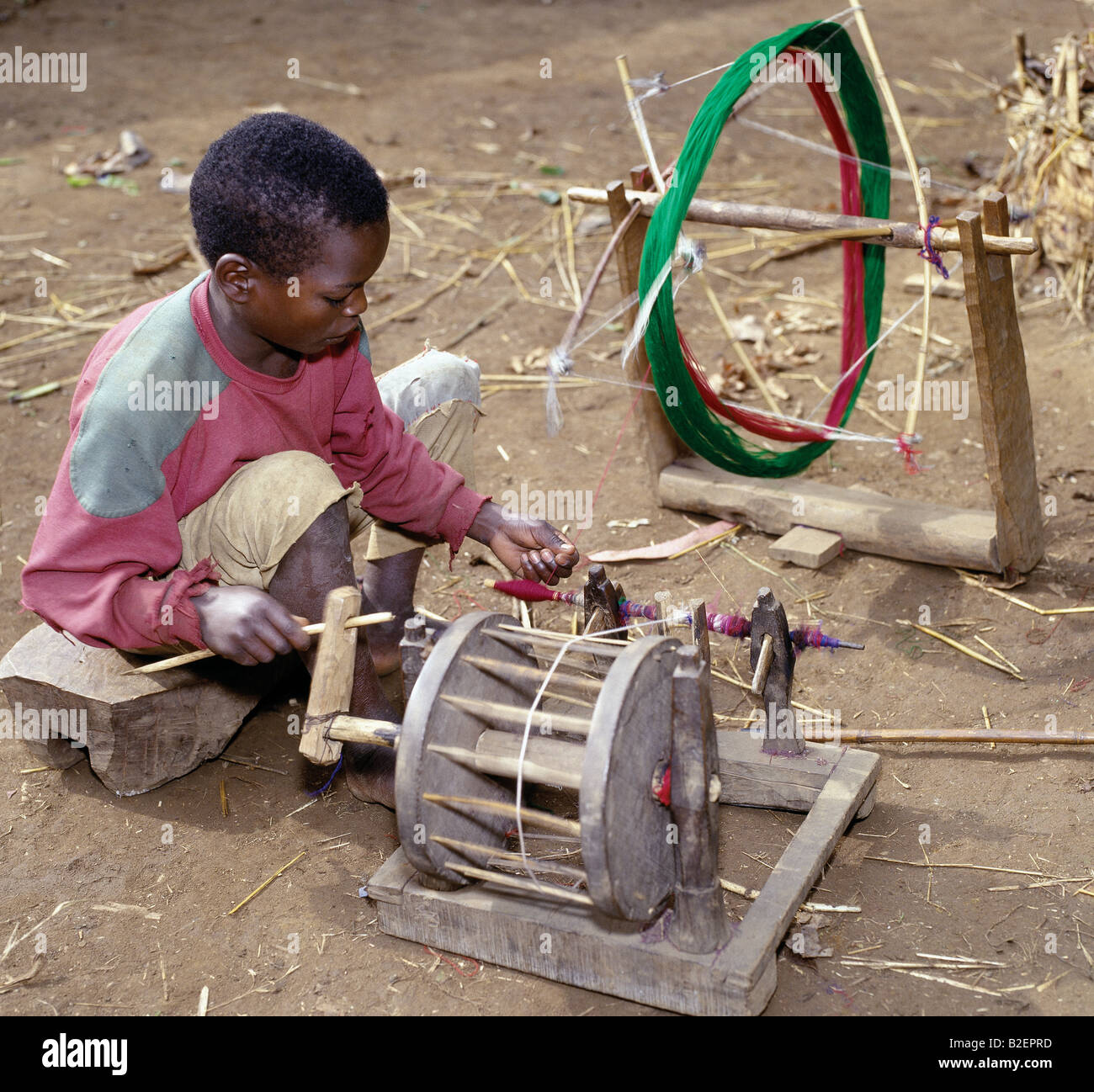 A young Dorze boy winds cotton onto a bobin for his father. Dorze men ...