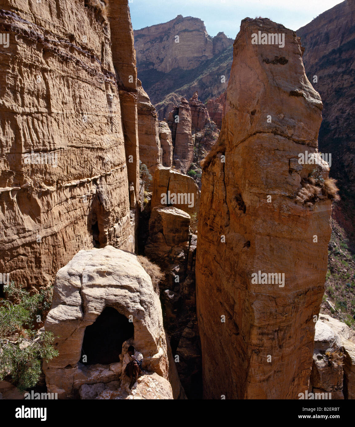 A man rests in the shade of a natural shelter close to the rock-hewn ...