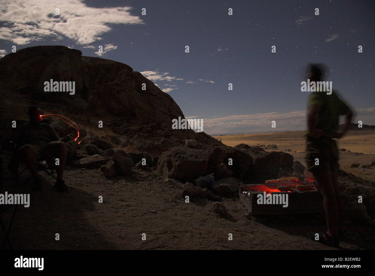 Campers cooking over a fire at night Stock Photo - Alamy