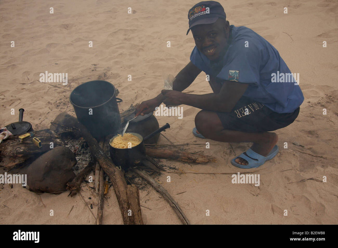 Cooking a meal on a log fire Stock Photo - Alamy
