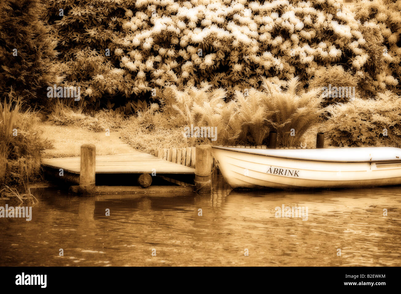 Spring Dock monochrome: A small row boat tied up to a dock that is ...