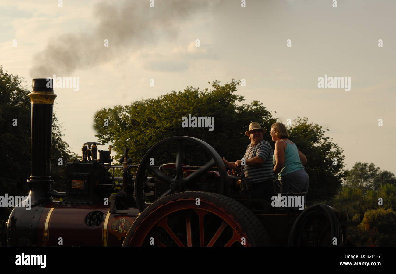 Two people driving steam engine at dusk Stock Photo - Alamy