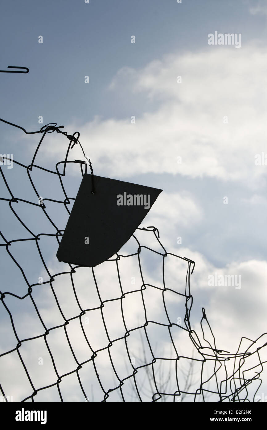 high broken damaged metal fence against dark sky Stock Photo - Alamy