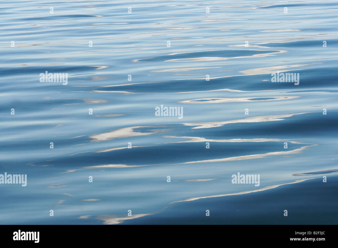 Azure sea water surface with ripple and cloud reflections Stock Photo ...