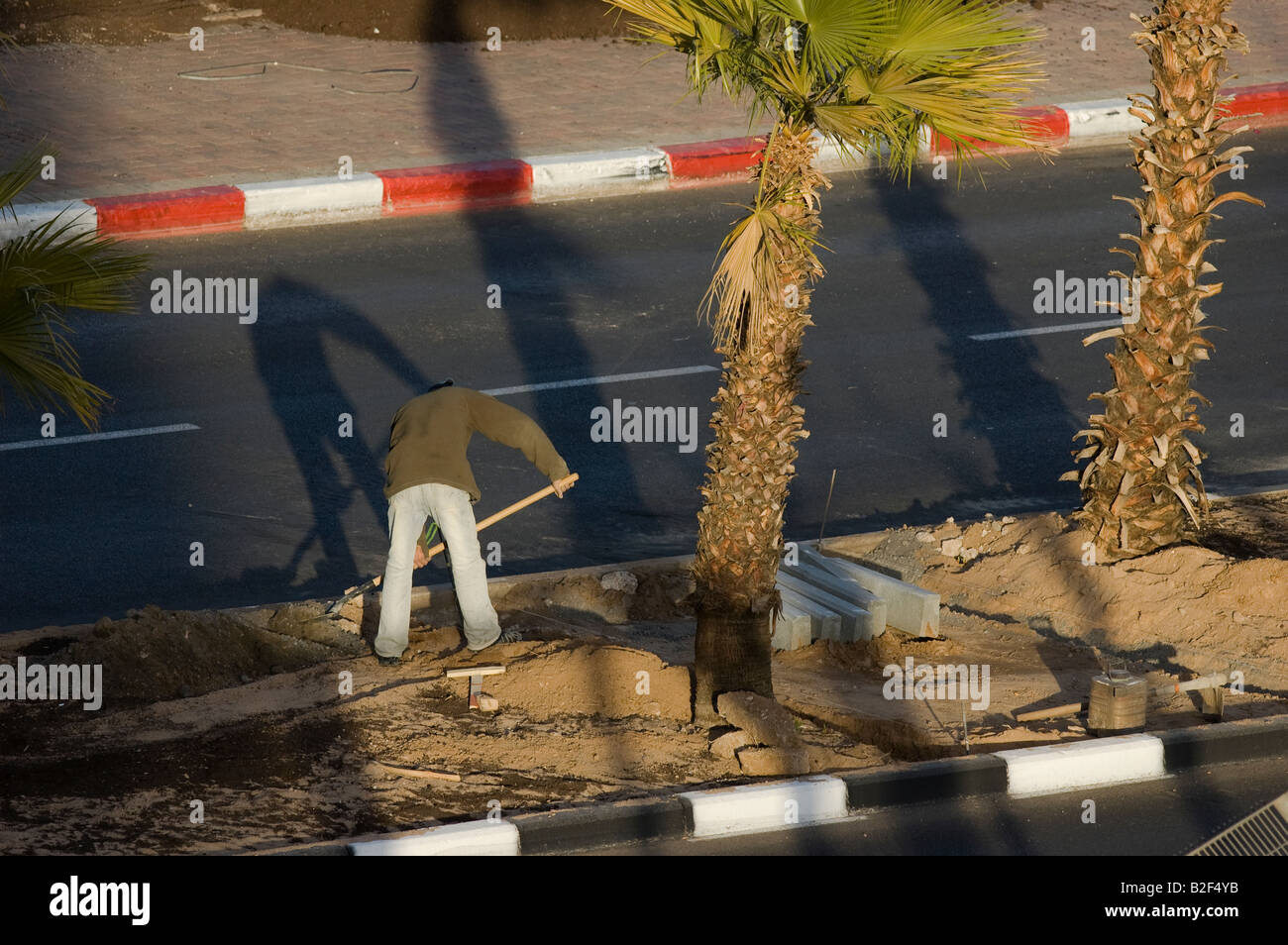 Construction worker shoveling sand Stock Photo - Alamy