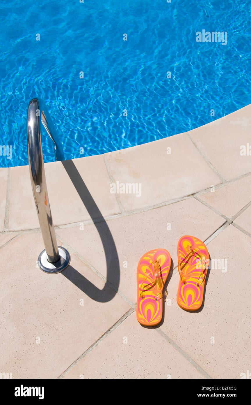 colourful flip flops on edge of swimming pool Stock Photo - Alamy