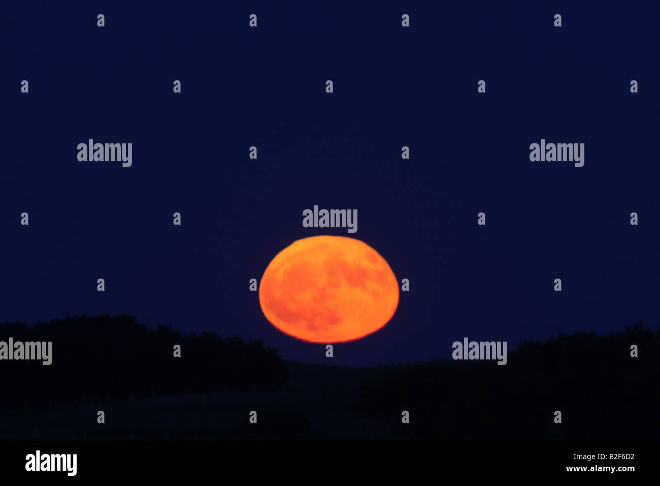 Full moon rising over hills Stock Photo - Alamy