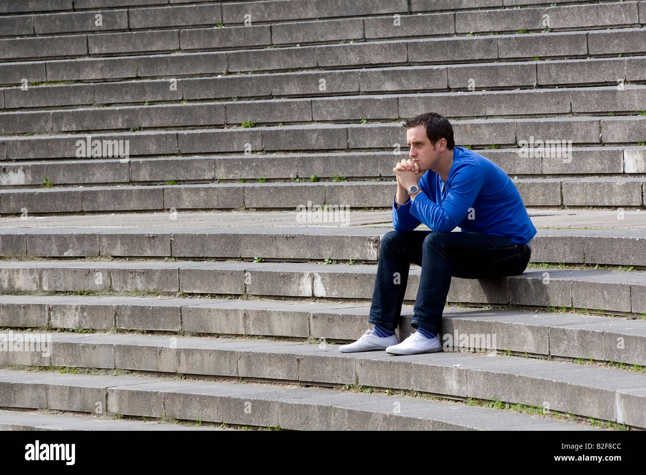 Young man sitting on steps outdoors Stock Photo - Alamy