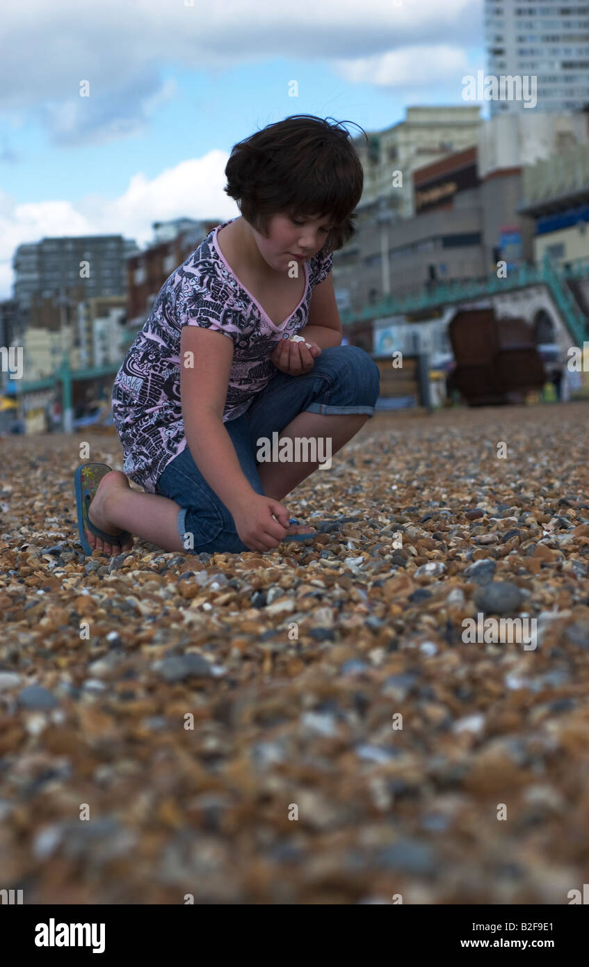 Girl picking up shells on a beach Stock Photo - Alamy