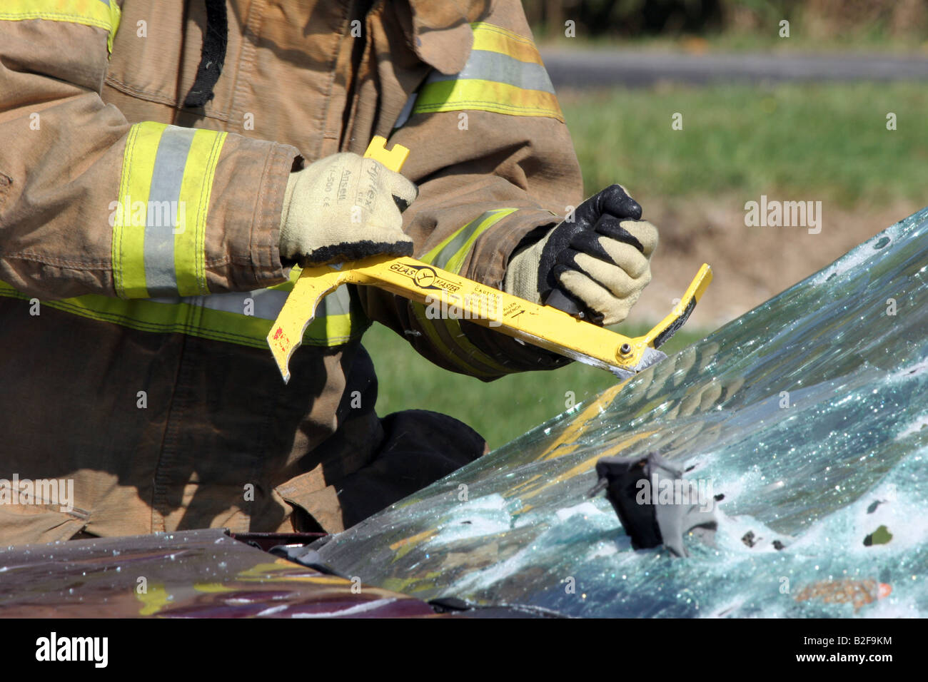 A firefighter using a Glass Master tool to cut out the windshield of a ...