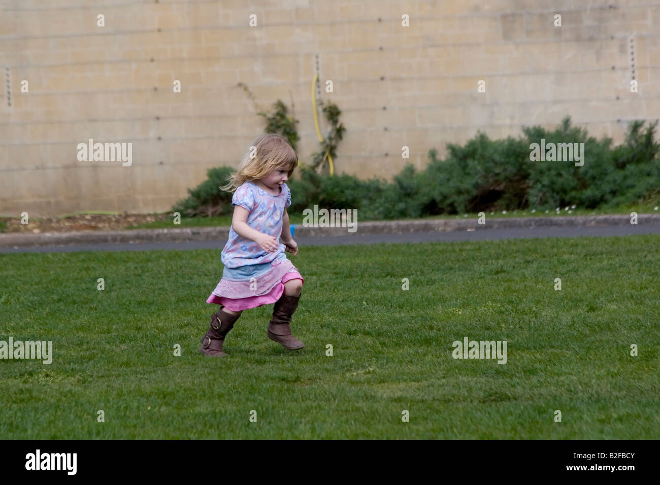 Young girl running through grass Stock Photo - Alamy