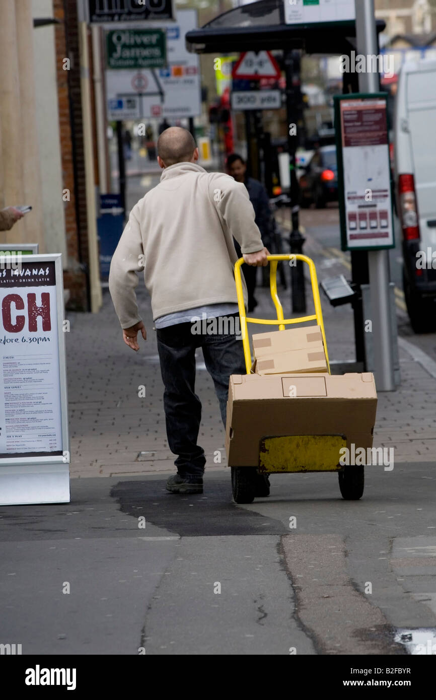 Man pulling boxes on sidewalk in Oxford, rear view Stock Photo - Alamy