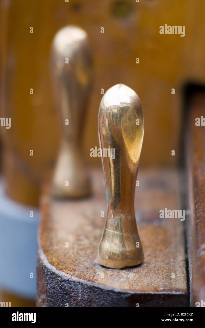 Two gold belaying pins insterted into the wood of a restored sailing ...
