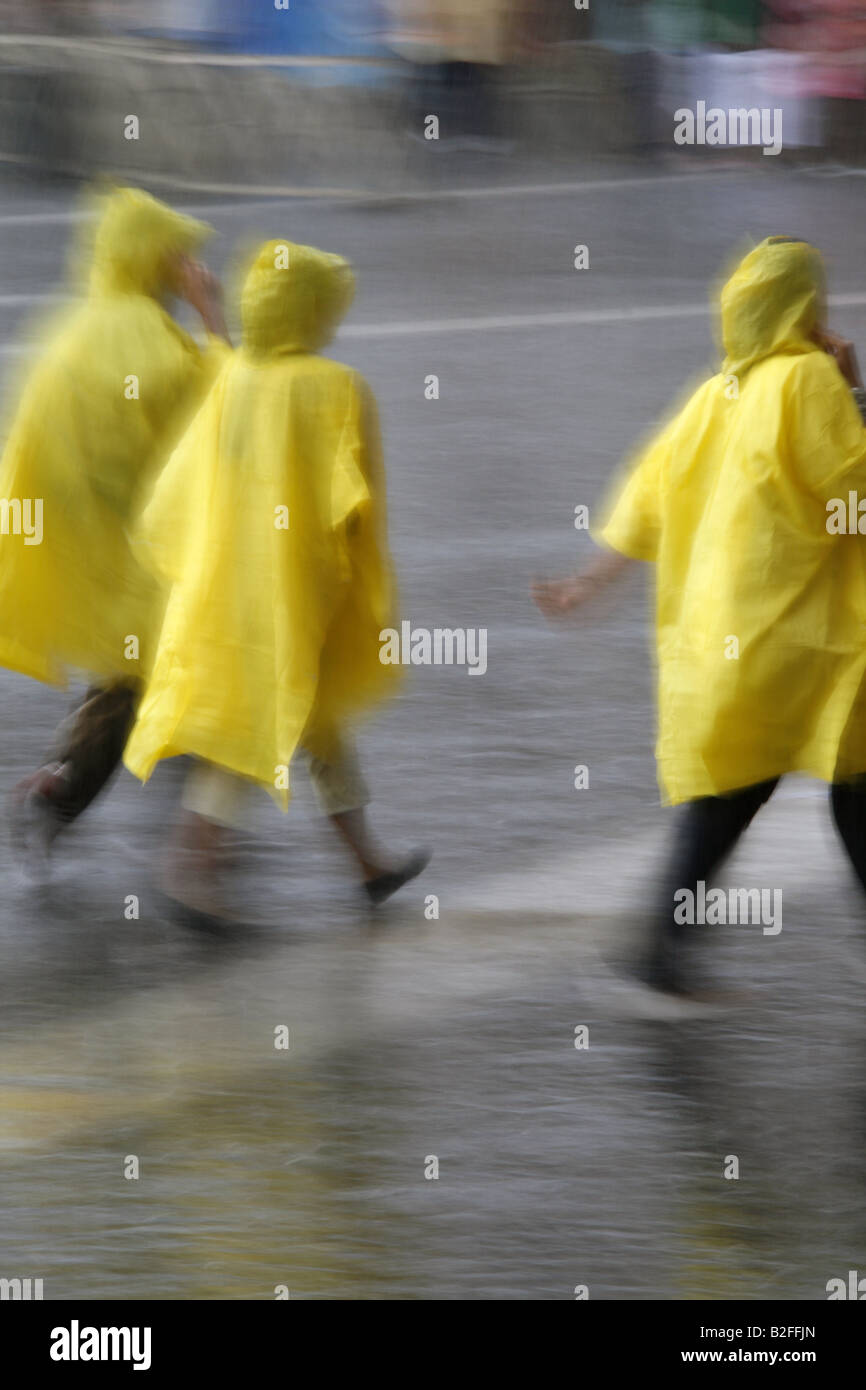 tourists wearing yellow waterproof cape in rain Stock Photo - Alamy