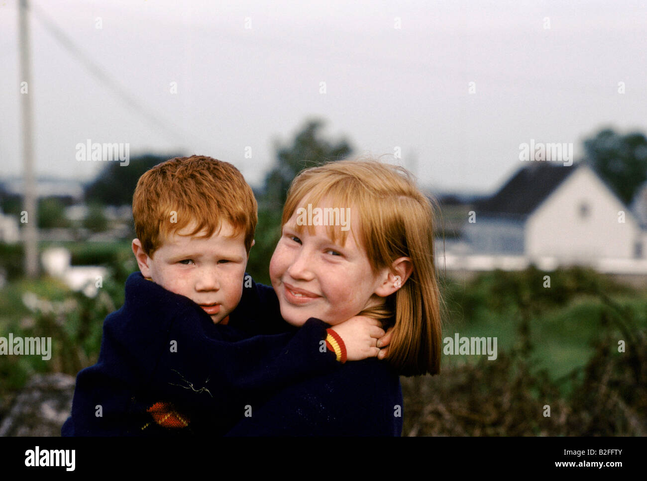 ginger haired siblings hugging in the garden Stock Photo - Alamy