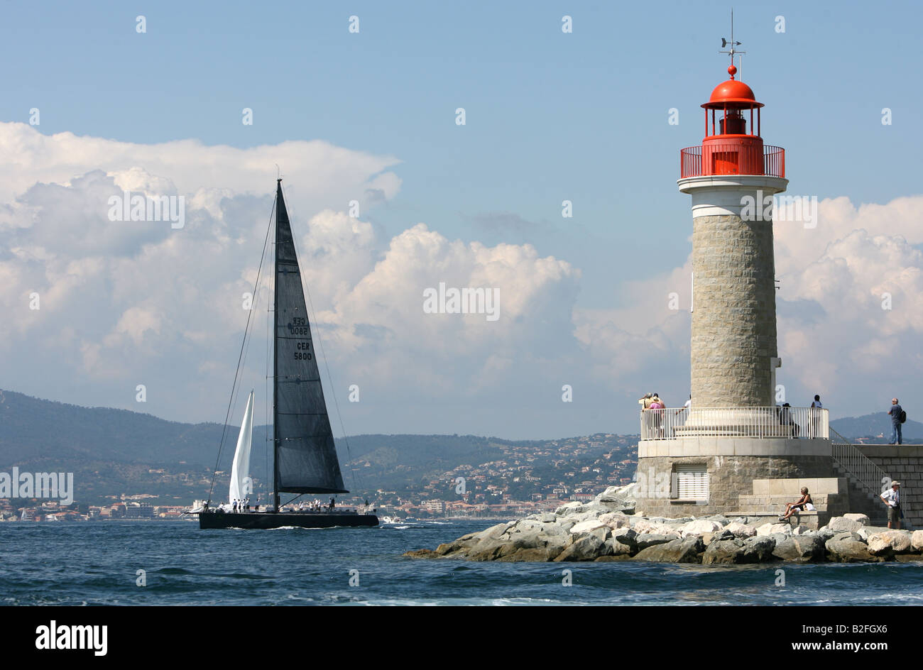 A racing yacht passes a lighthouse.s Stock Photo - Alamy