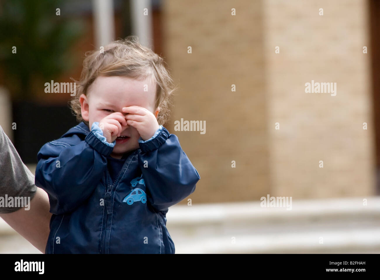 Young boy crying with hands on face Stock Photo - Alamy