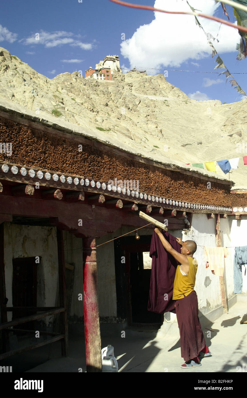 Tibetan buddhist monk man hanging curtain in front of monastery temple ...