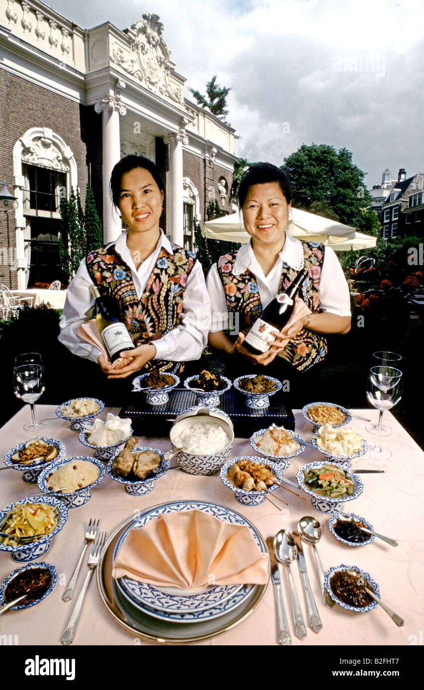 Waitresses at an Indonesian restaurant offer a full course meal with ...