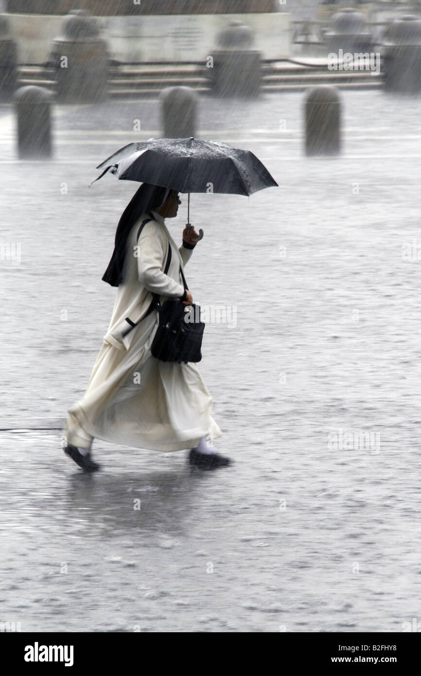 one nun in heavy rain in st peters square rome Stock Photo - Alamy