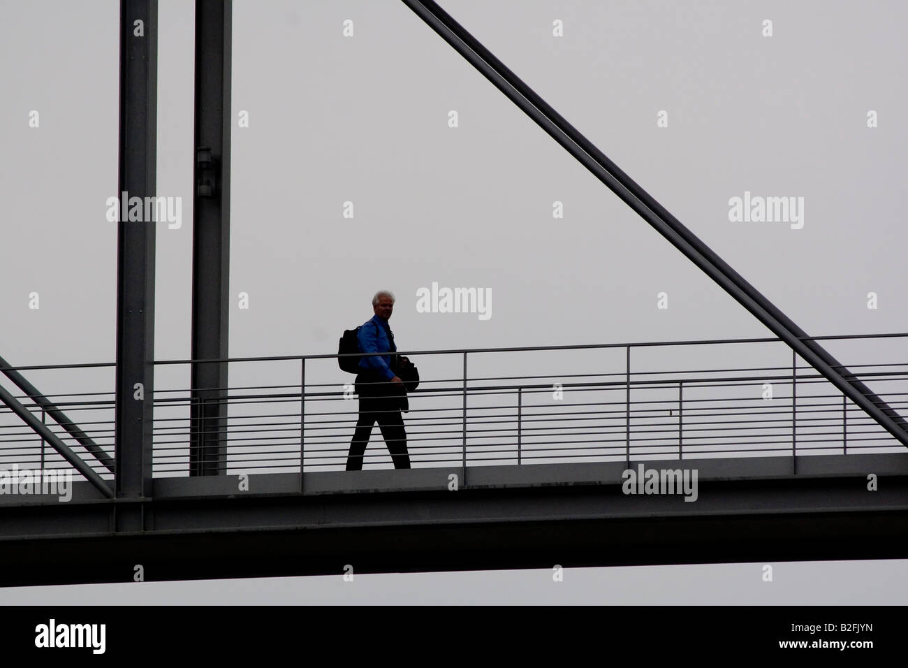 Senior man walking along elevated pedestrian walkway Stock Photo - Alamy