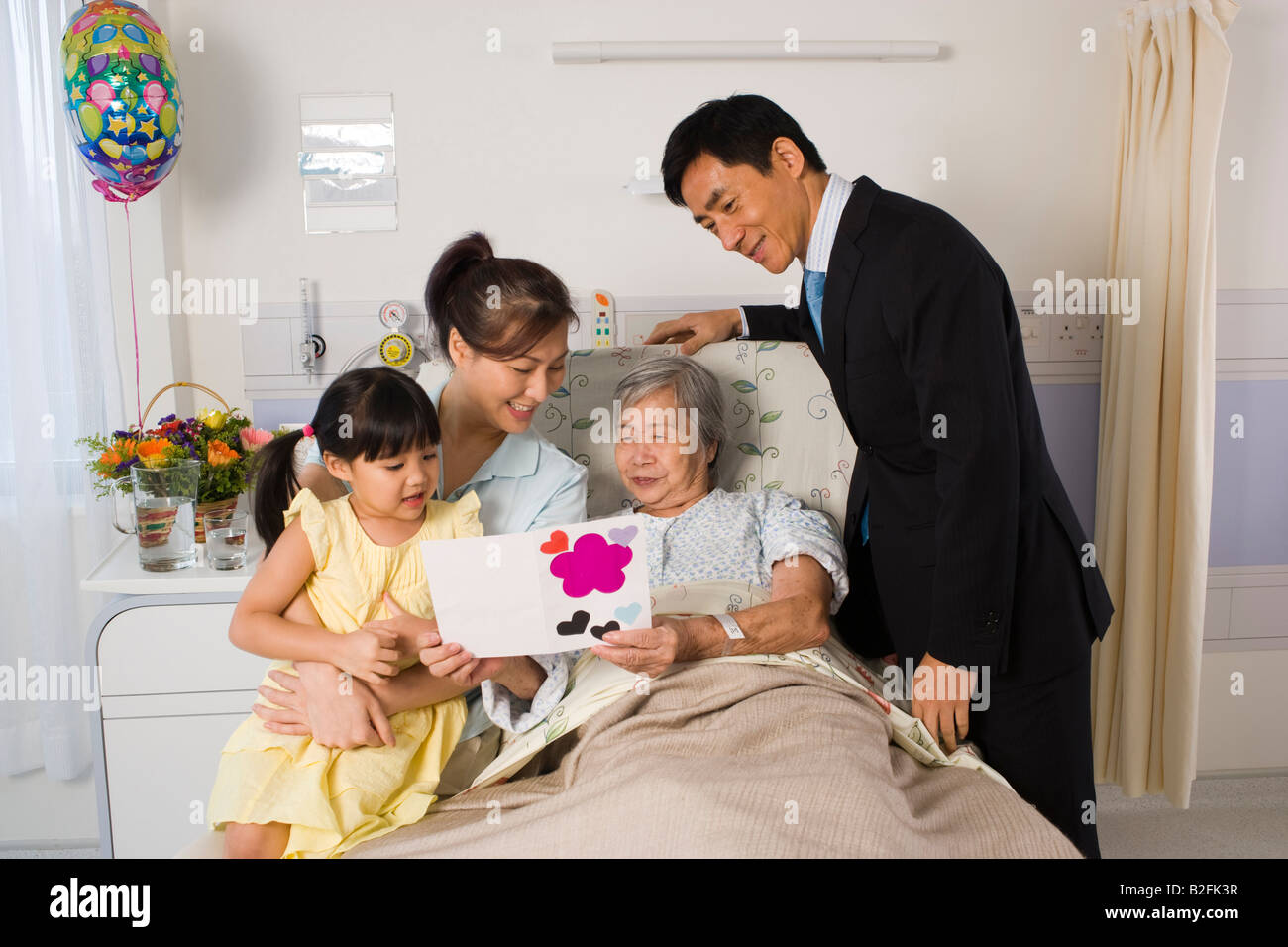 Female patient and her family looking at a Get Well card Stock Photo ...