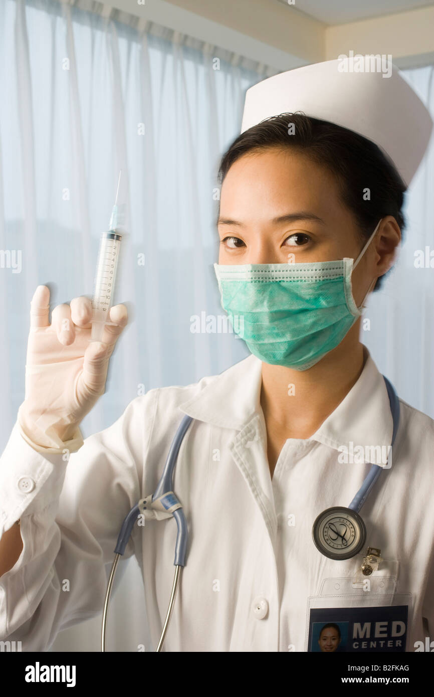 Portrait of a female nurse holding an injection Stock Photo - Alamy
