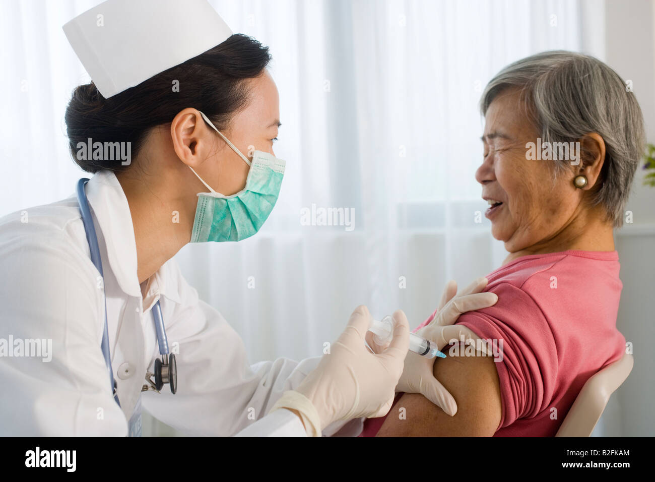 Female nurse giving an injection to a patient Stock Photo - Alamy