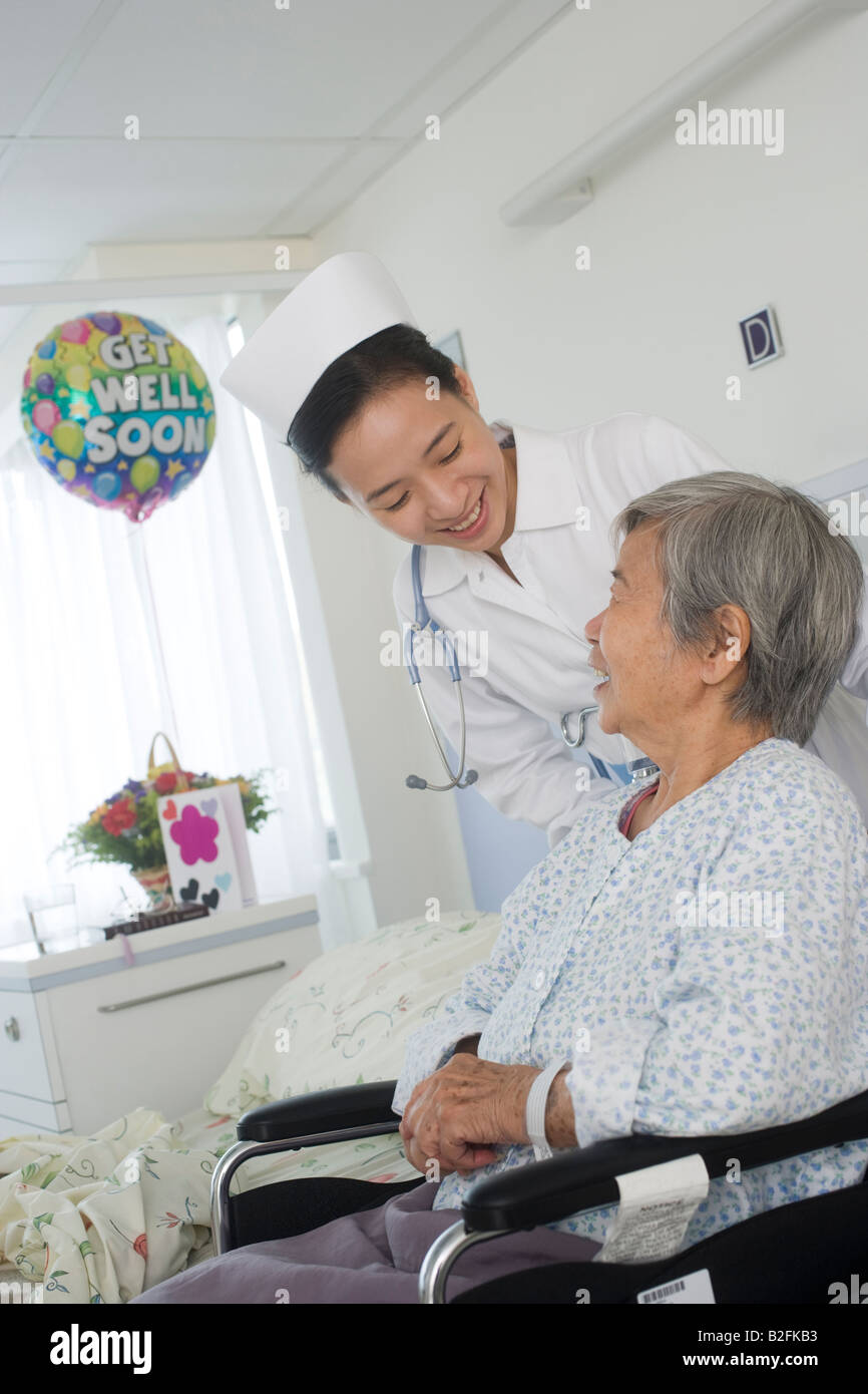 Female nurse taking care of a patient and smiling Stock Photo - Alamy