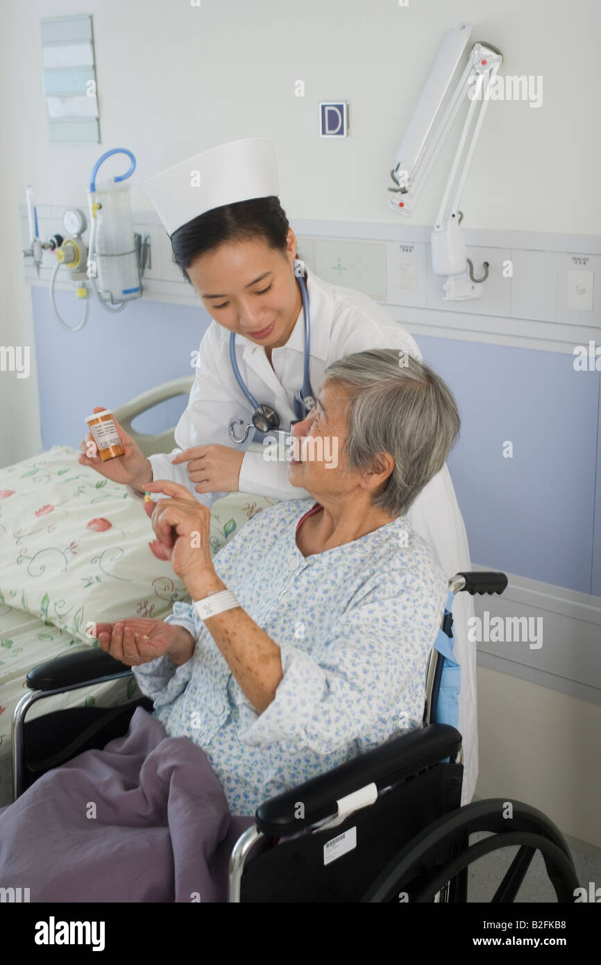 Female patient holding a capsule and talking to a nurse Stock Photo - Alamy