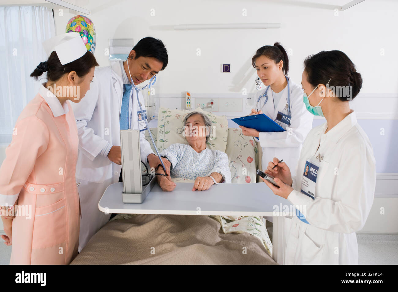 Two doctors and two nurses examining a female patient Stock Photo - Alamy
