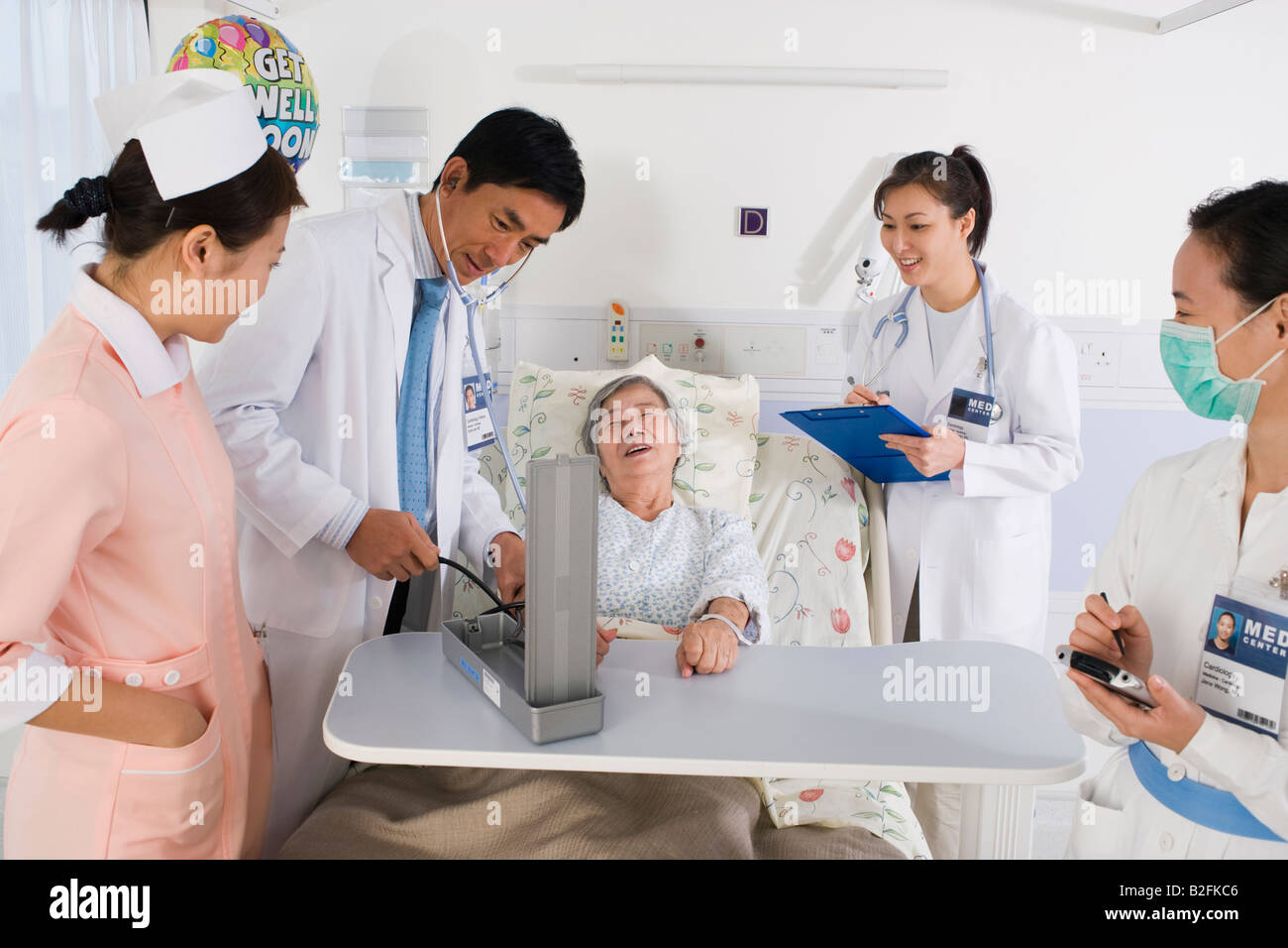 Two doctors and two nurses examining a female patient Stock Photo - Alamy