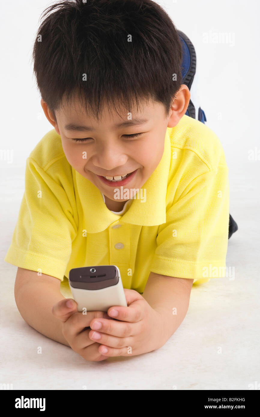 Close-up of a boy using a mobile phone and smiling Stock Photo - Alamy