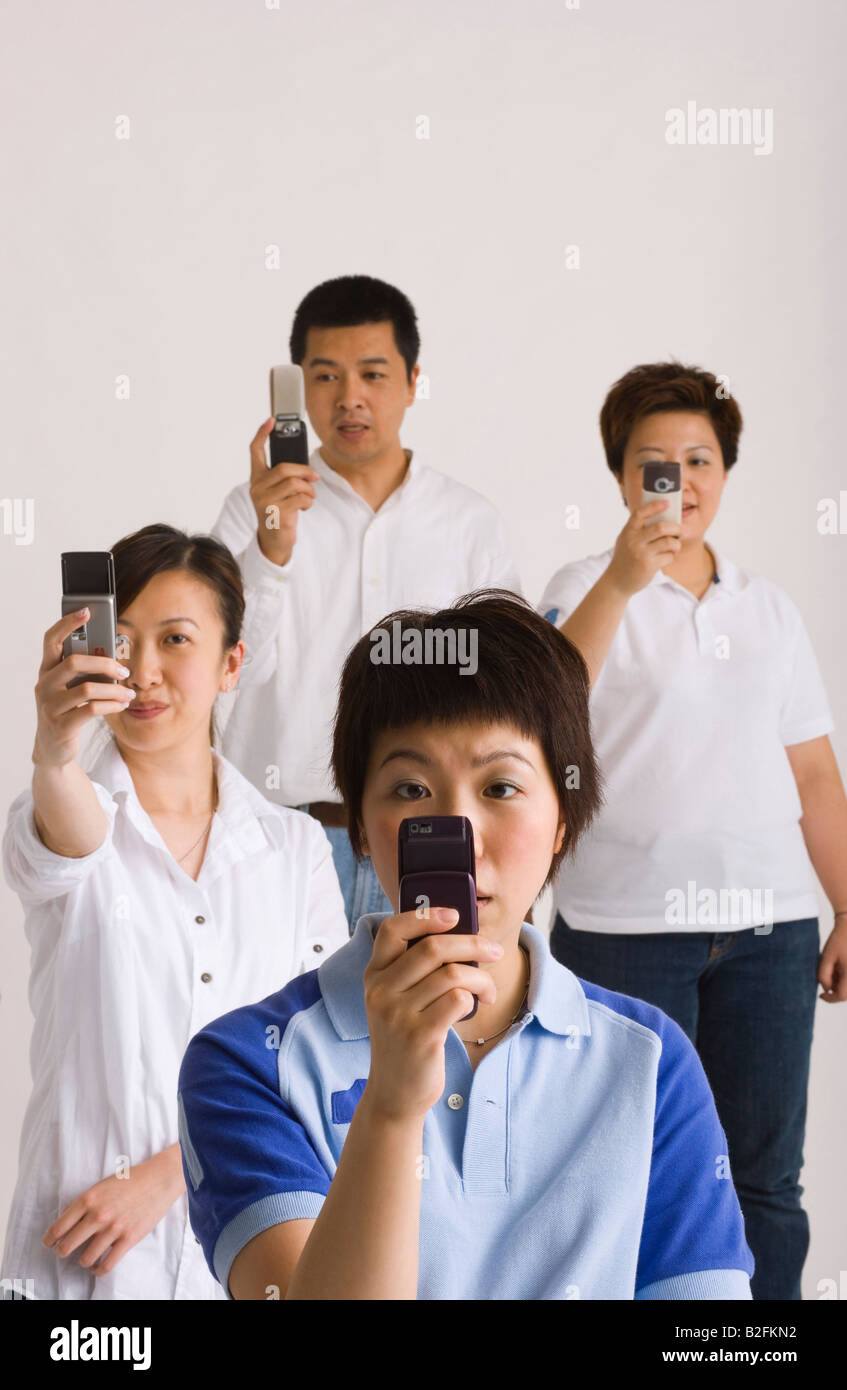 Three mid adult women and a mid adult man photographing with mobile ...