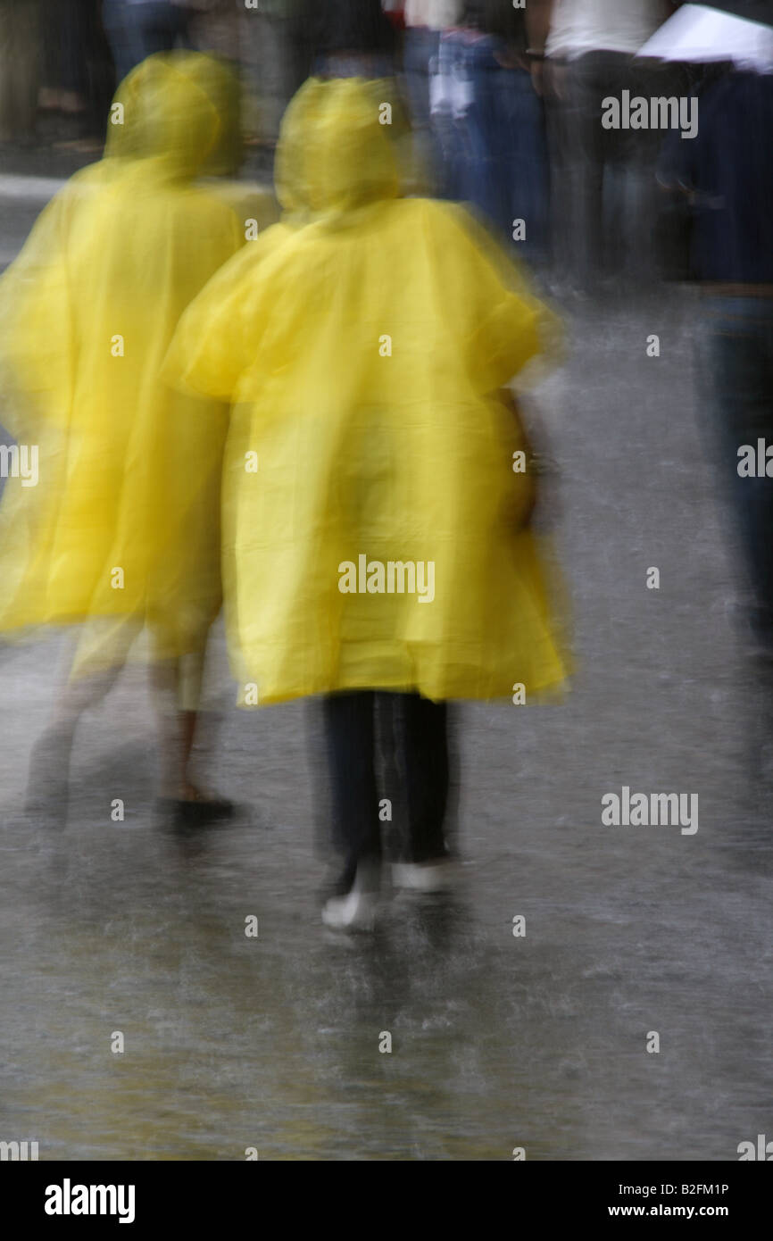 people wearing yellow waterproof coat cape in rain Stock Photo - Alamy